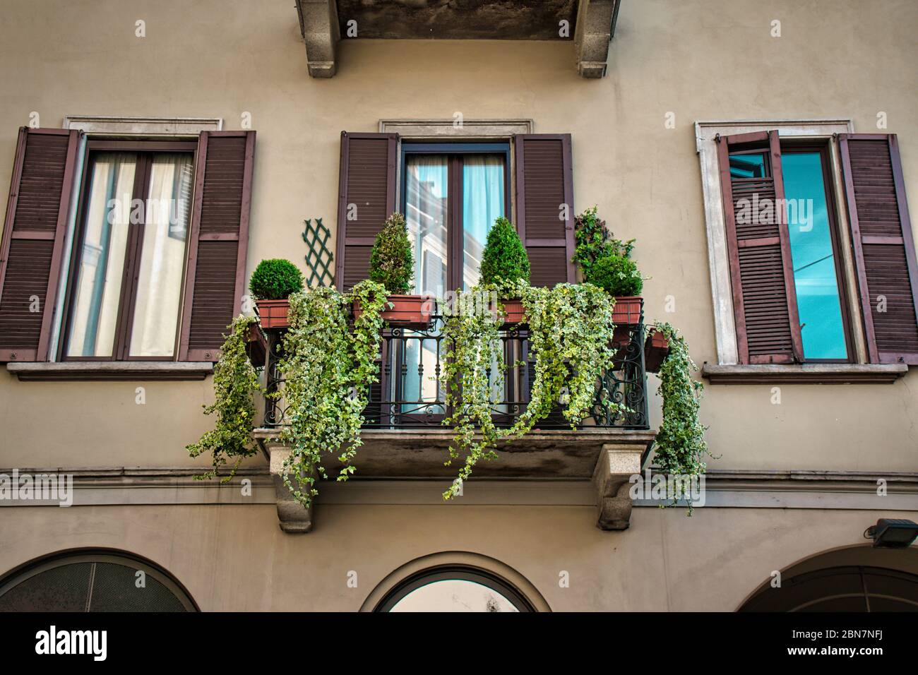 Milan, Italy 05.12.2020: An old traditional italian balcony with green ...