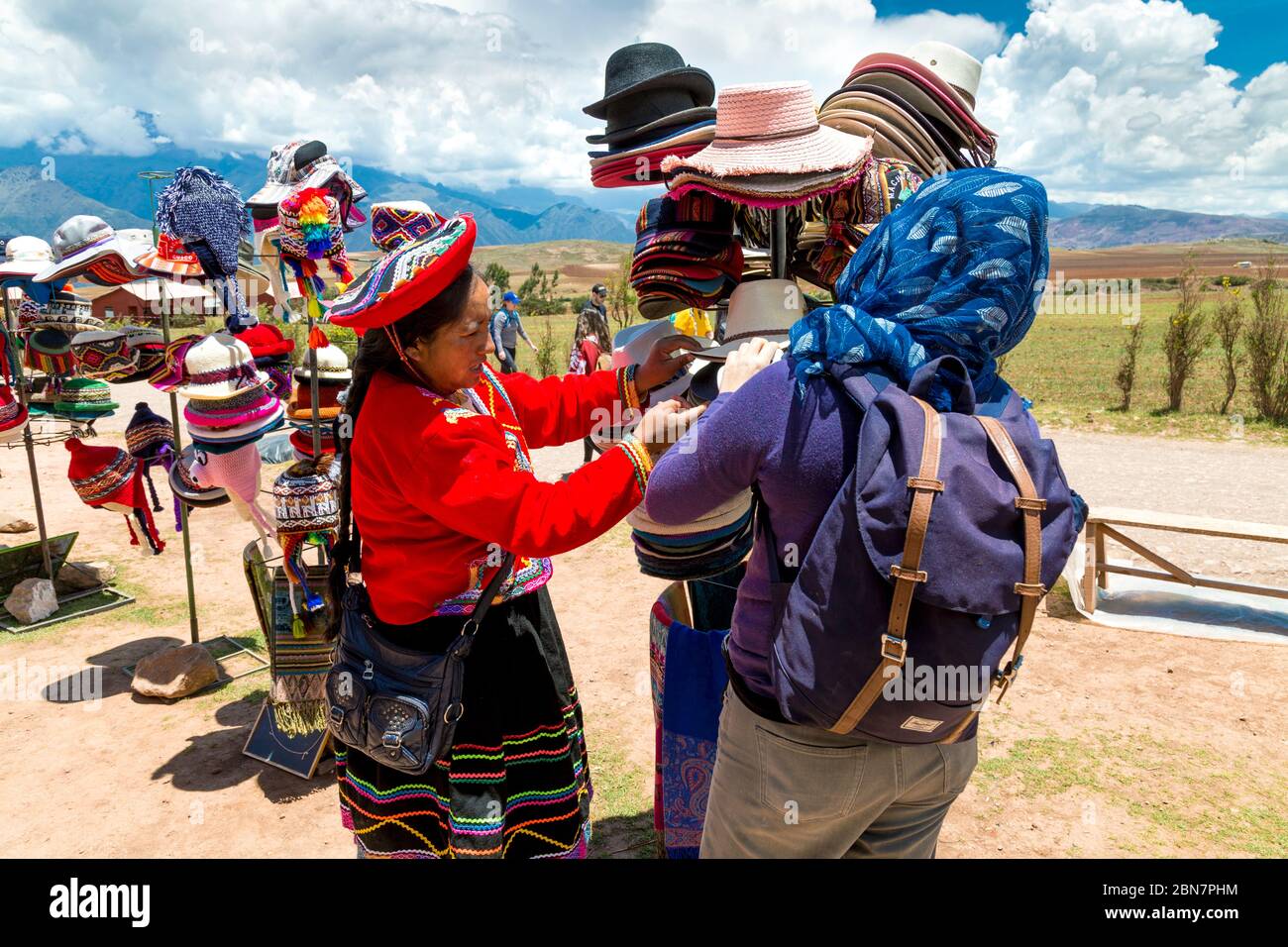 Tourist shopping for hats at a souvenir stall, Peruvian woman in ...