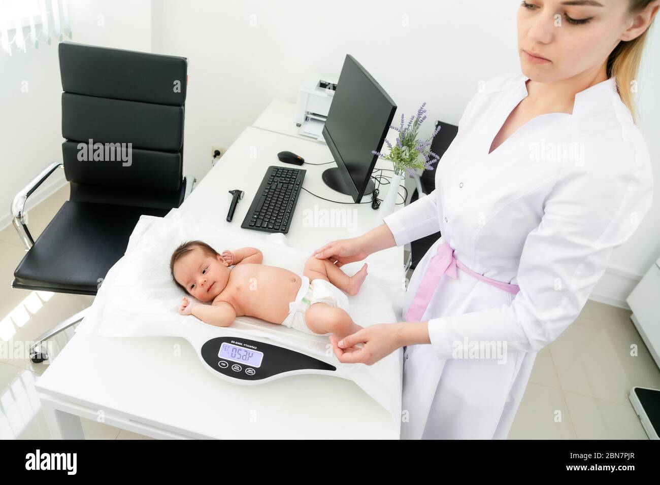 Close-up of a doctor checking weight of cute little baby. Healthcare ...