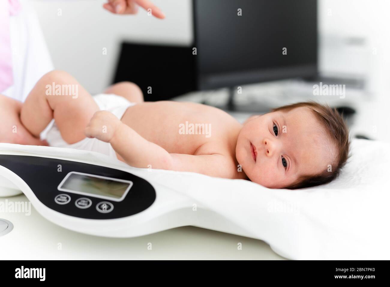 Close-up of a doctor checking weight of cute little baby. Healthcare ...