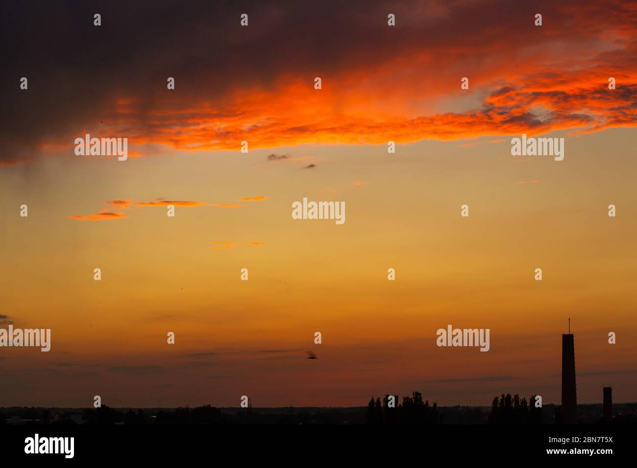 Black thunderclouds at sunset. Bright orange sunset and dark clouds ...