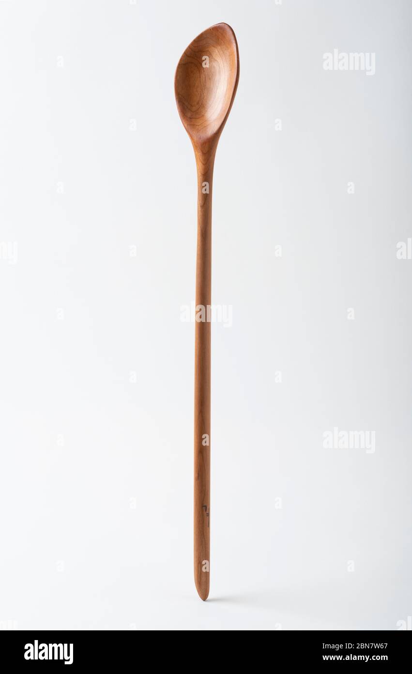 A long, narrow spoon made of cherry wood, recalling craftsmanship and ...