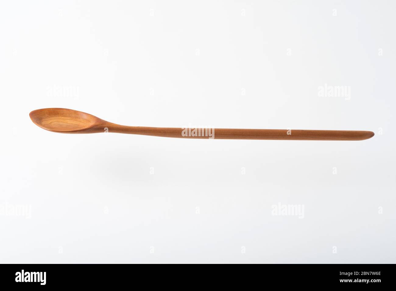 A long, narrow spoon made of cherry wood, recalling craftsmanship and ...