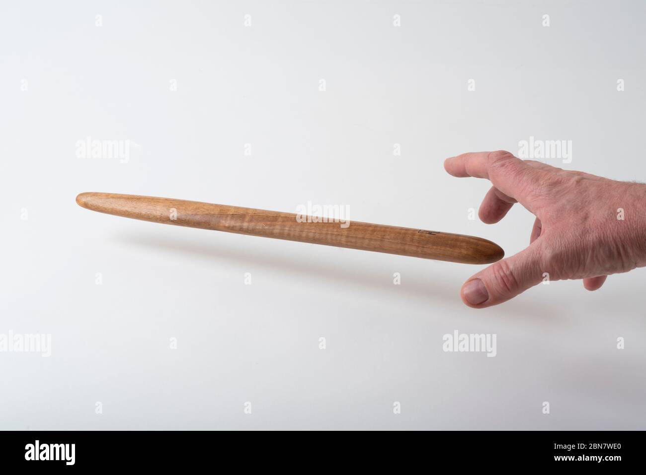 A male hand reaches for a handmade spirtle made from oak, photographed ...