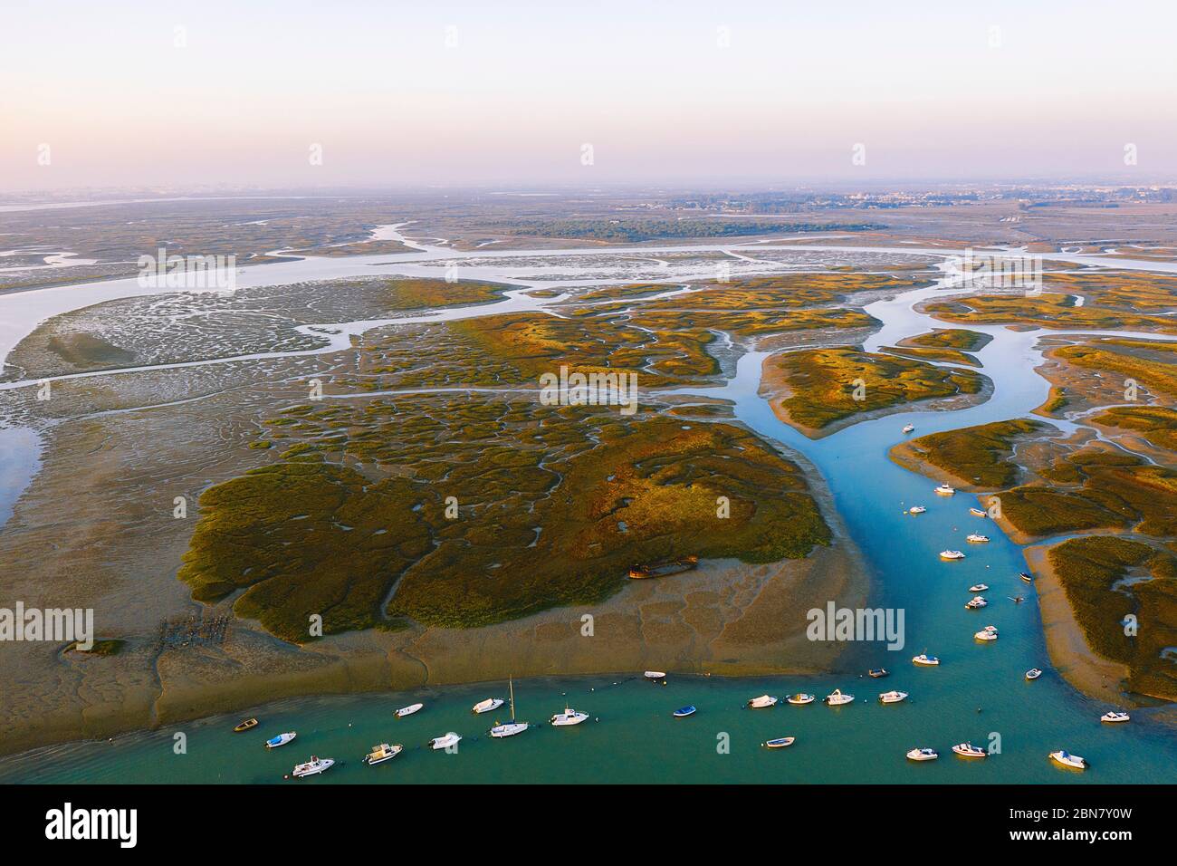 aerial view of marine wetlands at low tide with boats moored in ...