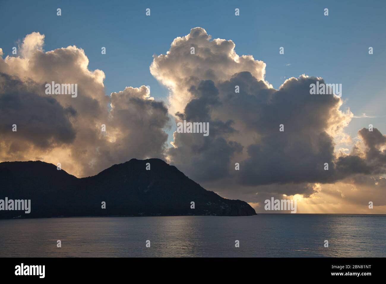 Dramatic sunrise with sun tinged large clouds in a blue sky over the ...