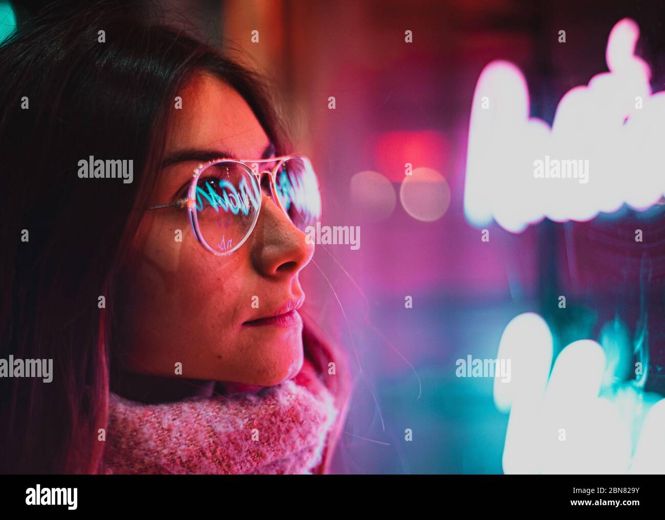 Neon light reflected on girl's glasses Stock Photo - Alamy