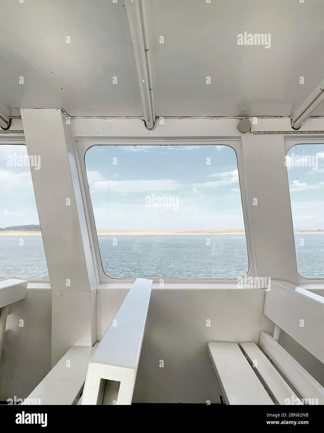 Vertical overlook to a sea from a yacht window with white interior ...