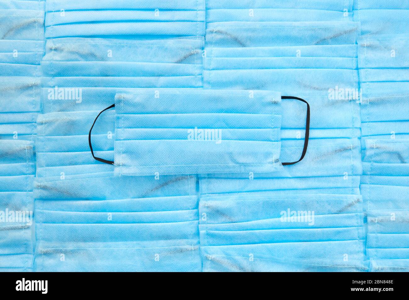 Blue medical mask on the same masks and color background Stock Photo ...