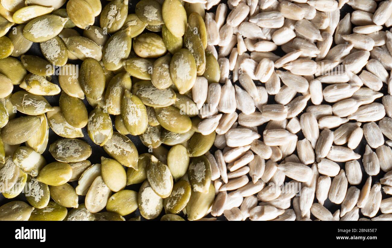 Top view of different seeds as a background. Two parts of sunflower and ...