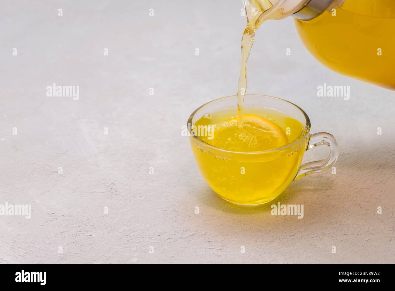 Immunity boost turmeric tea pouring into glass cup on neutral light ...