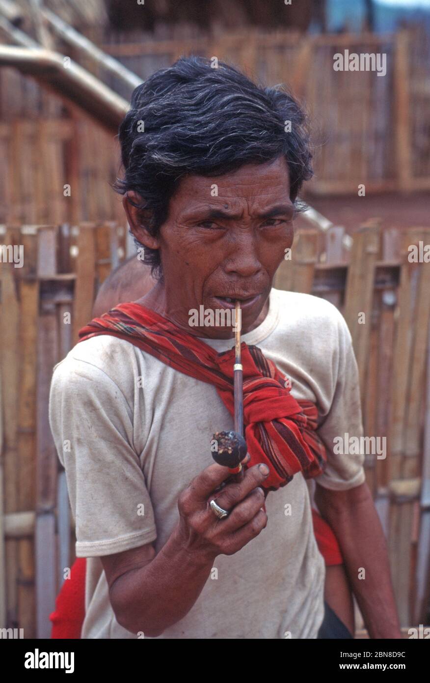 Lahu hill tribe man in a village in Northern Thailand smoking a pipe ...