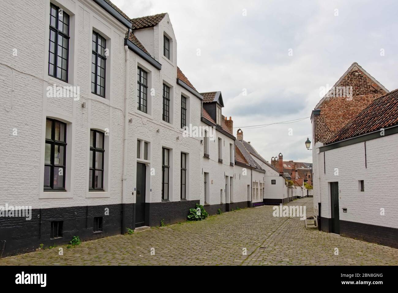 Cobblestone streets with small cosy white painted brick houses of the ...