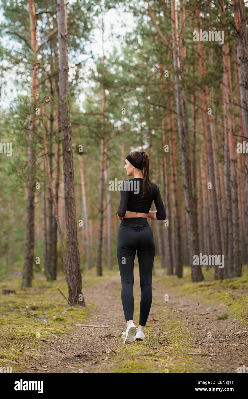 Pretty young girl runner in the forest. Walking woman. Female runner ...