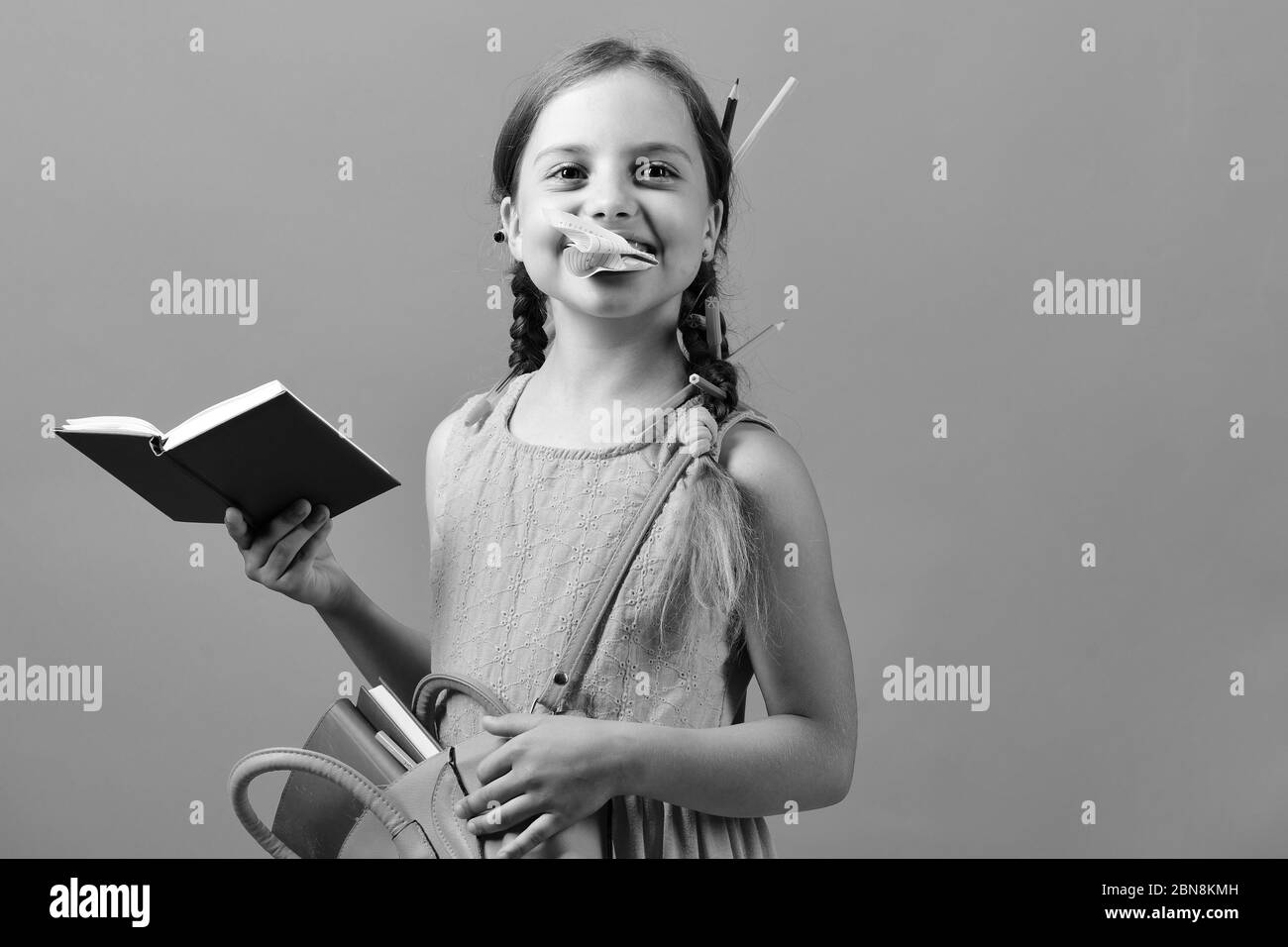 Back to school and education concept. Girl eats paper from blue ...