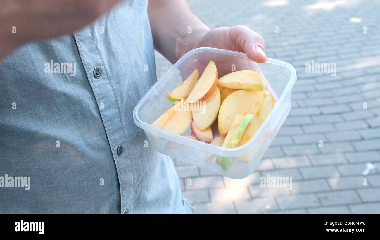 Man hand, eat pieces sliced the apples from the container Stock Photo ...