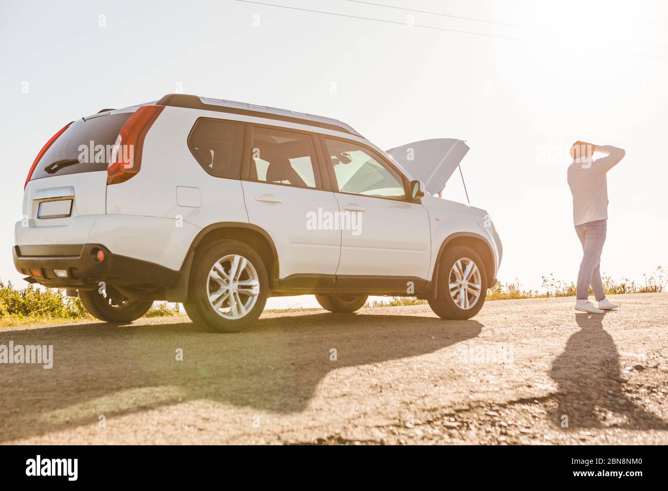 man standing near car with opened hood on sunset Stock Photo - Alamy