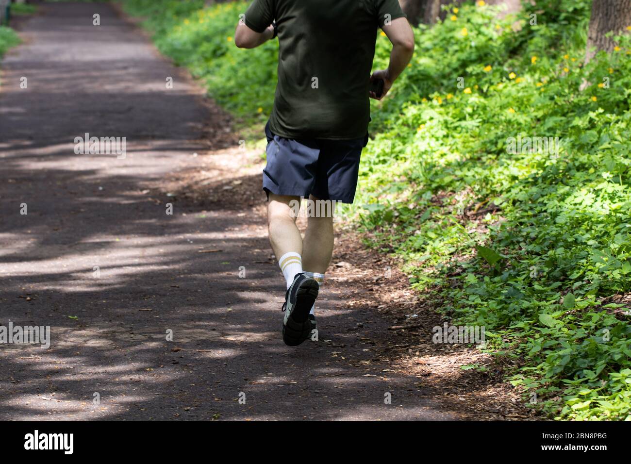 Young man runs in the park. Morning run Stock Photo - Alamy