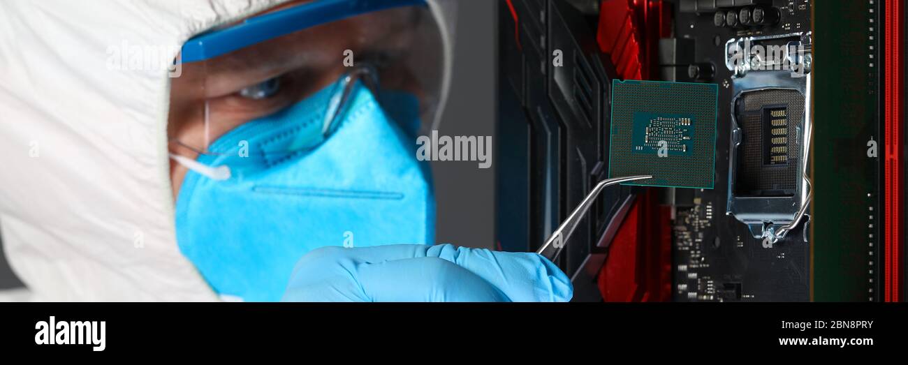 Man in uniform sets microchip electronic equipment Stock Photo - Alamy