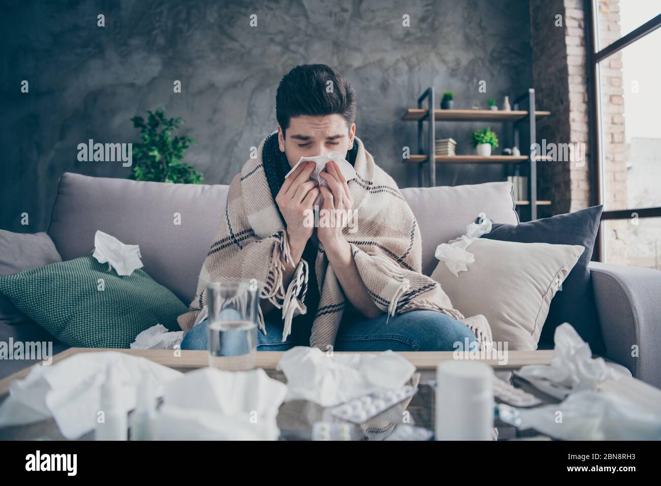 Portrait of his he nice attractive sick weak guy sitting on divan ...