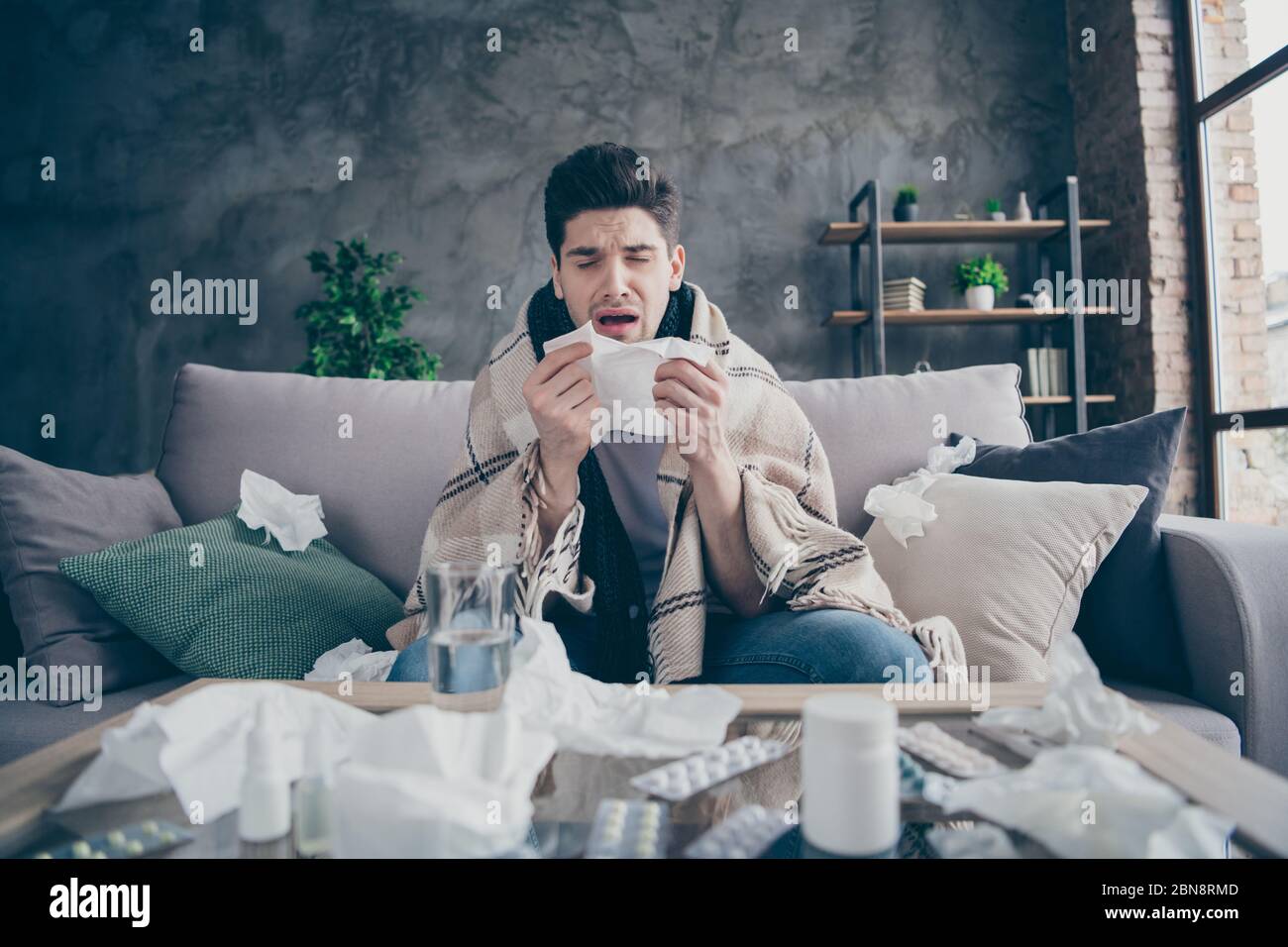 Portrait of his he nice attractive sad sick guy sitting on divan ...