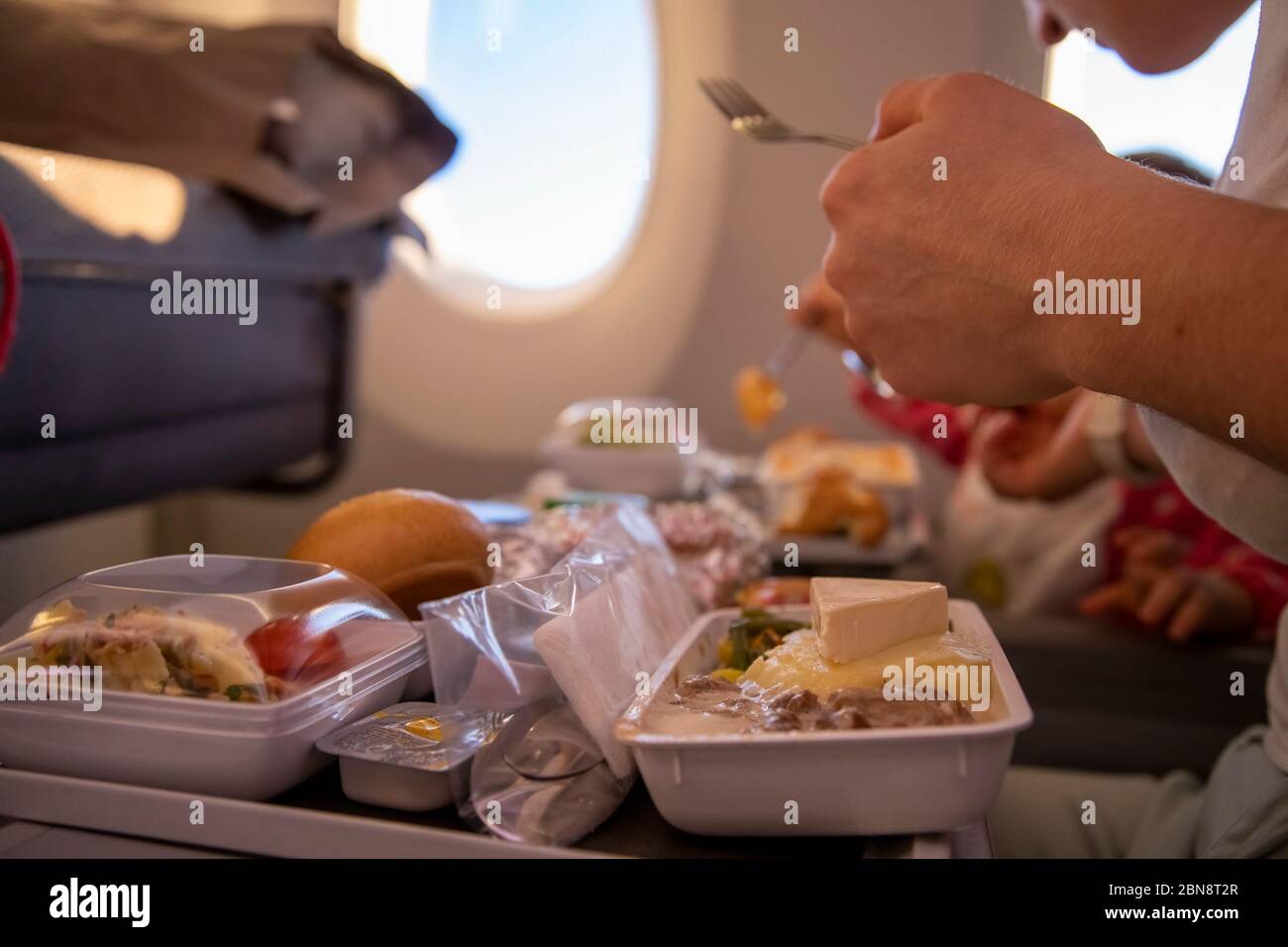 close-up passenger plane eats tasty hot meal on board on a folding ...