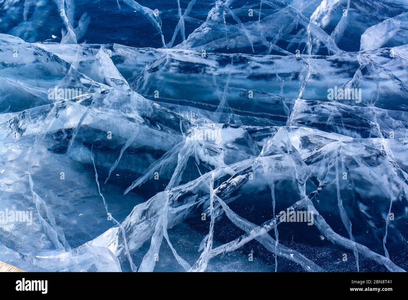 Many beautiful cracks in the clear blue ice. Layered thick ice ...