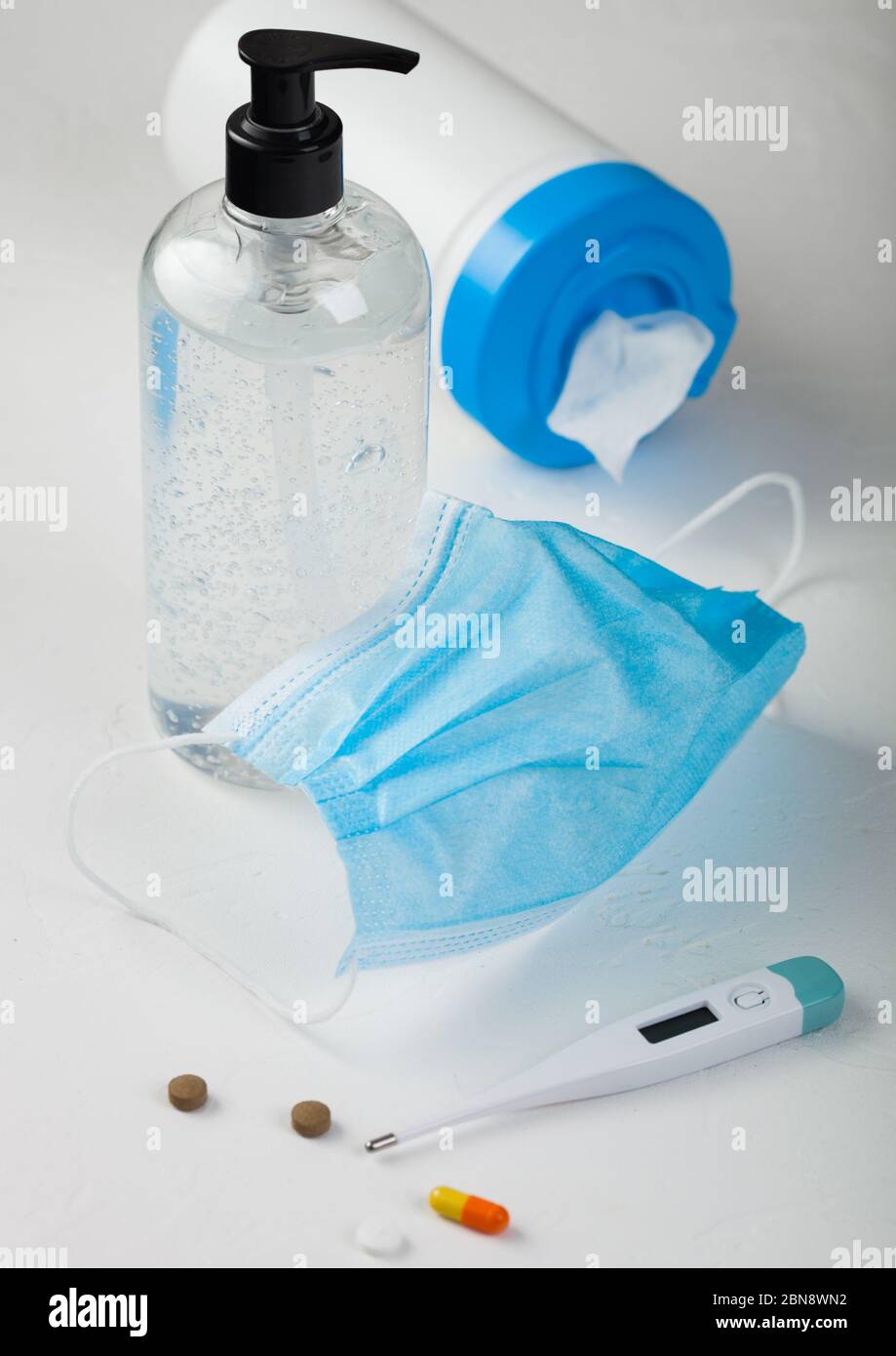 Medical face mask with sanitizer gel, alcohol hand wipes on white with ...
