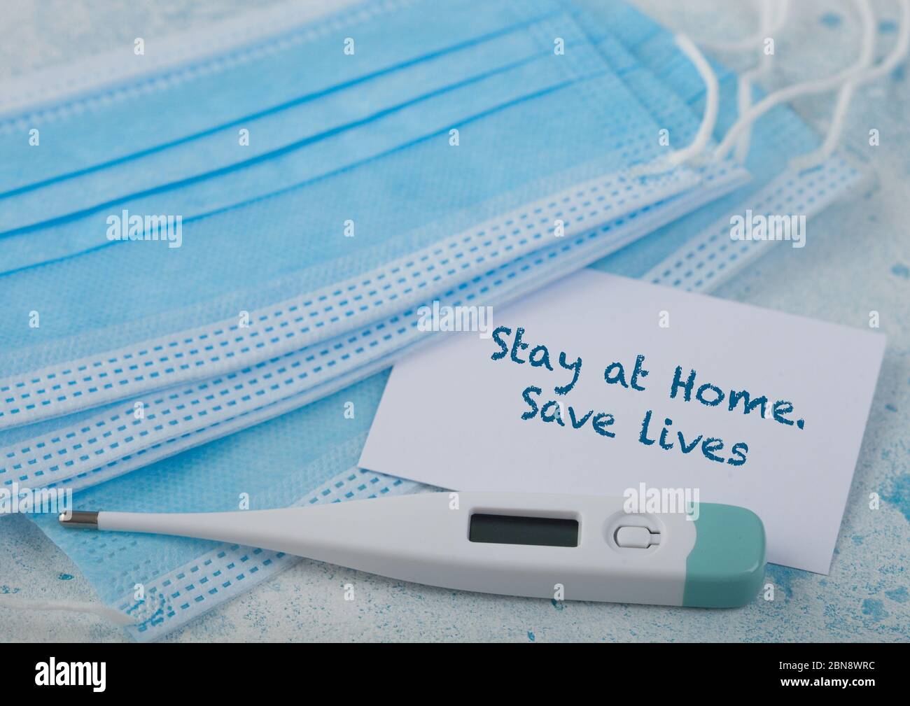 Medical face mask with white card and thermometer on blue. Best ...