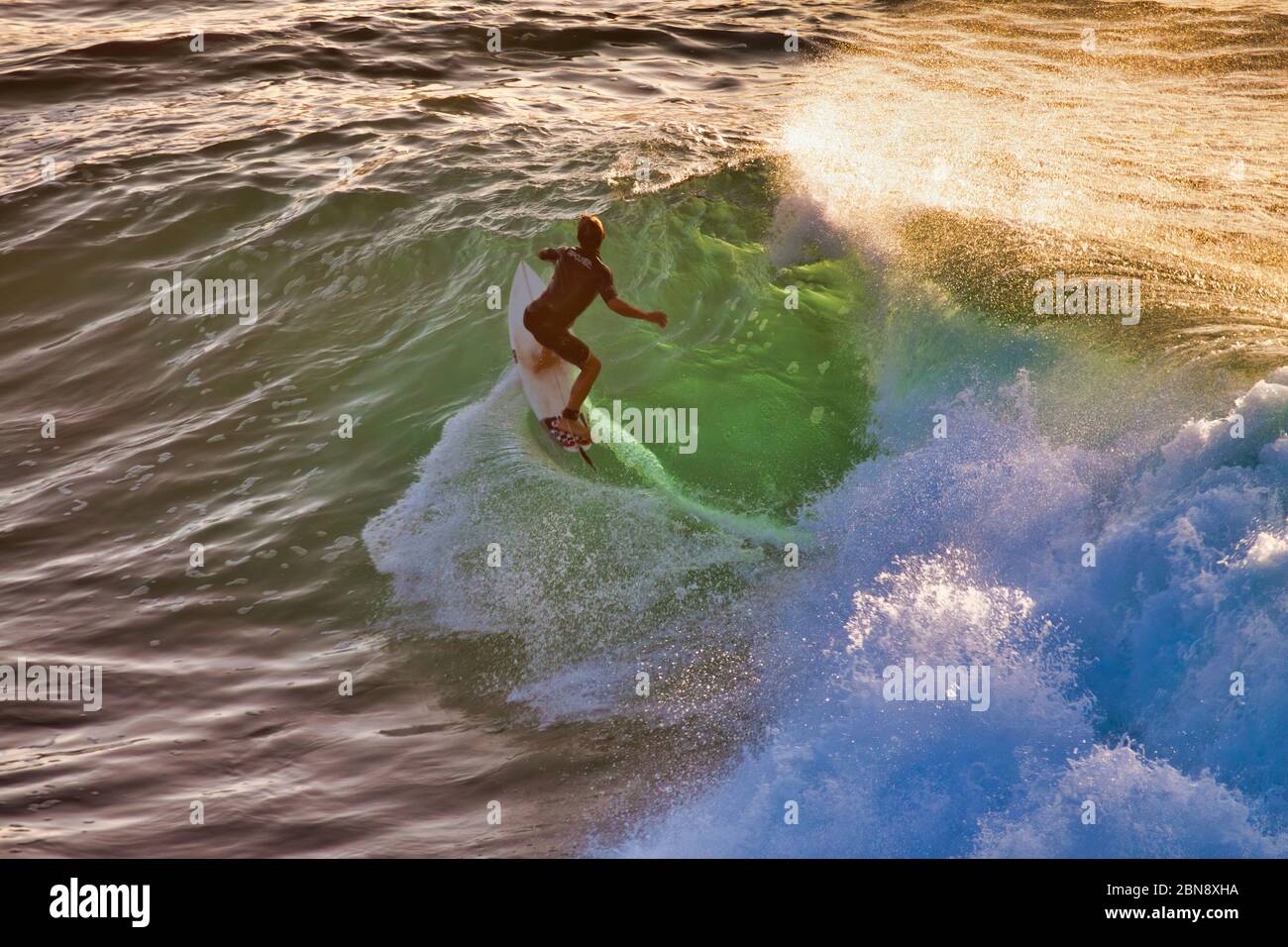 Unrecognizable surfer riding a last wave of the day on Maui Stock Photo ...