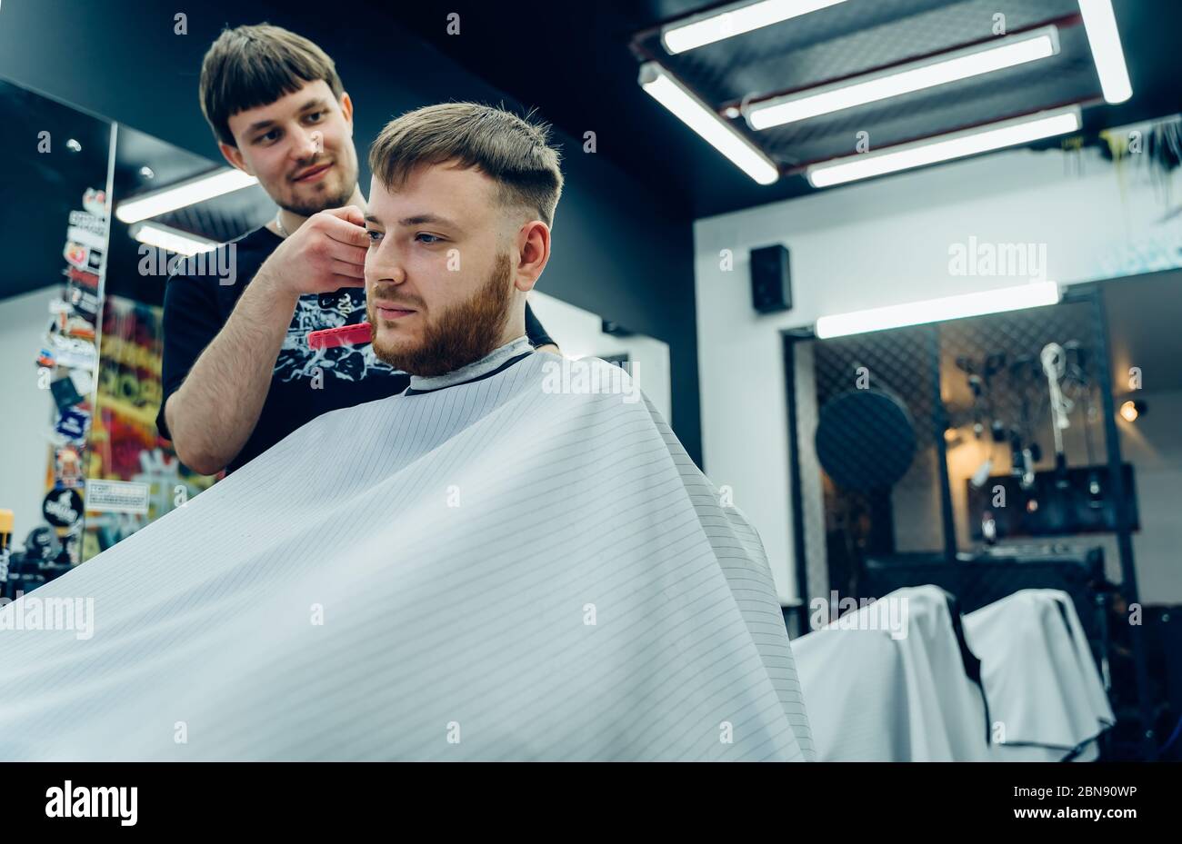 Male haircut with electric razor. Barber makes haircut for client at ...