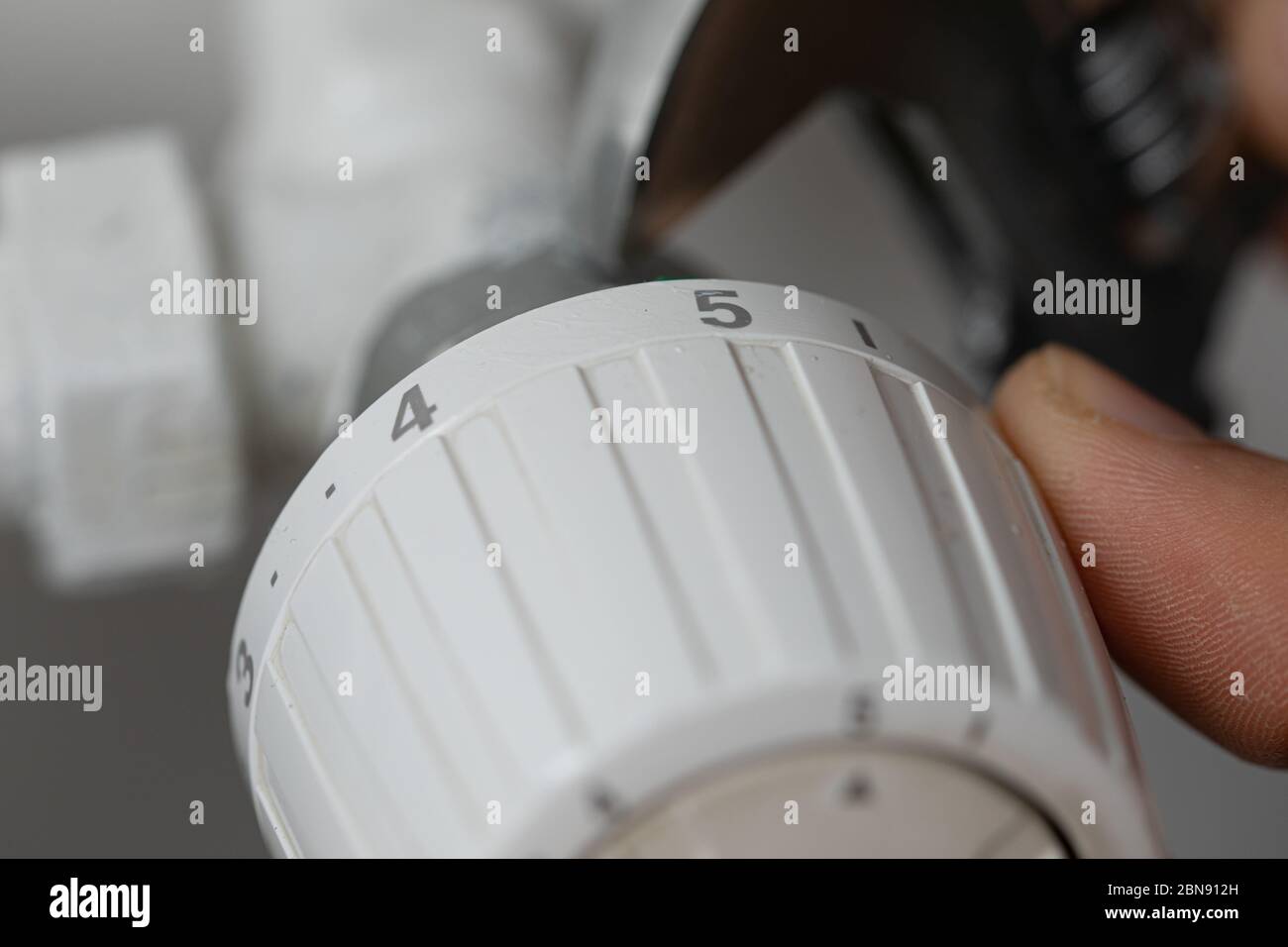A heater repair hand on white wall Stock Photo - Alamy
