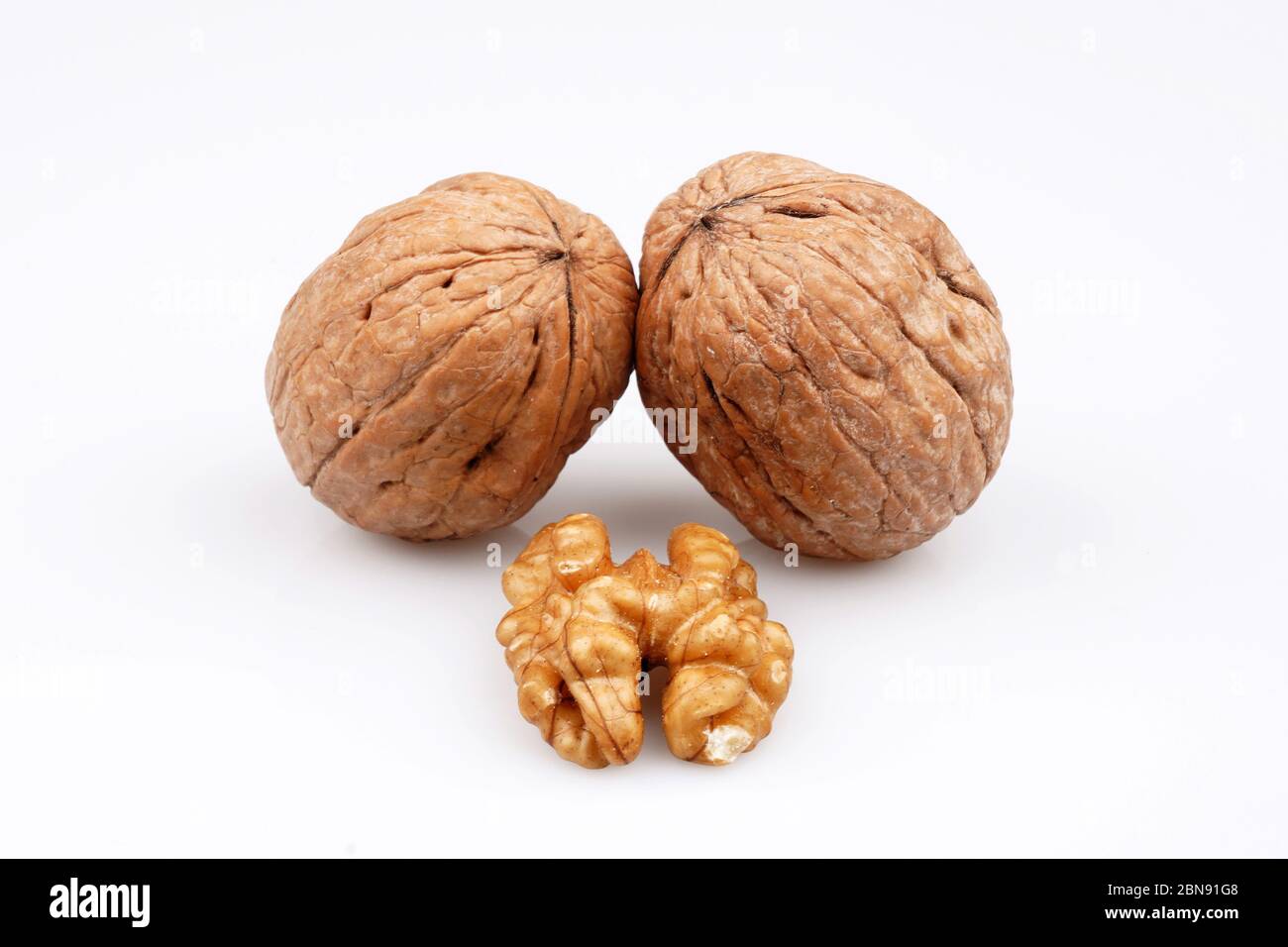 Two walnuts and walnuts with organic shell on a white background Stock ...