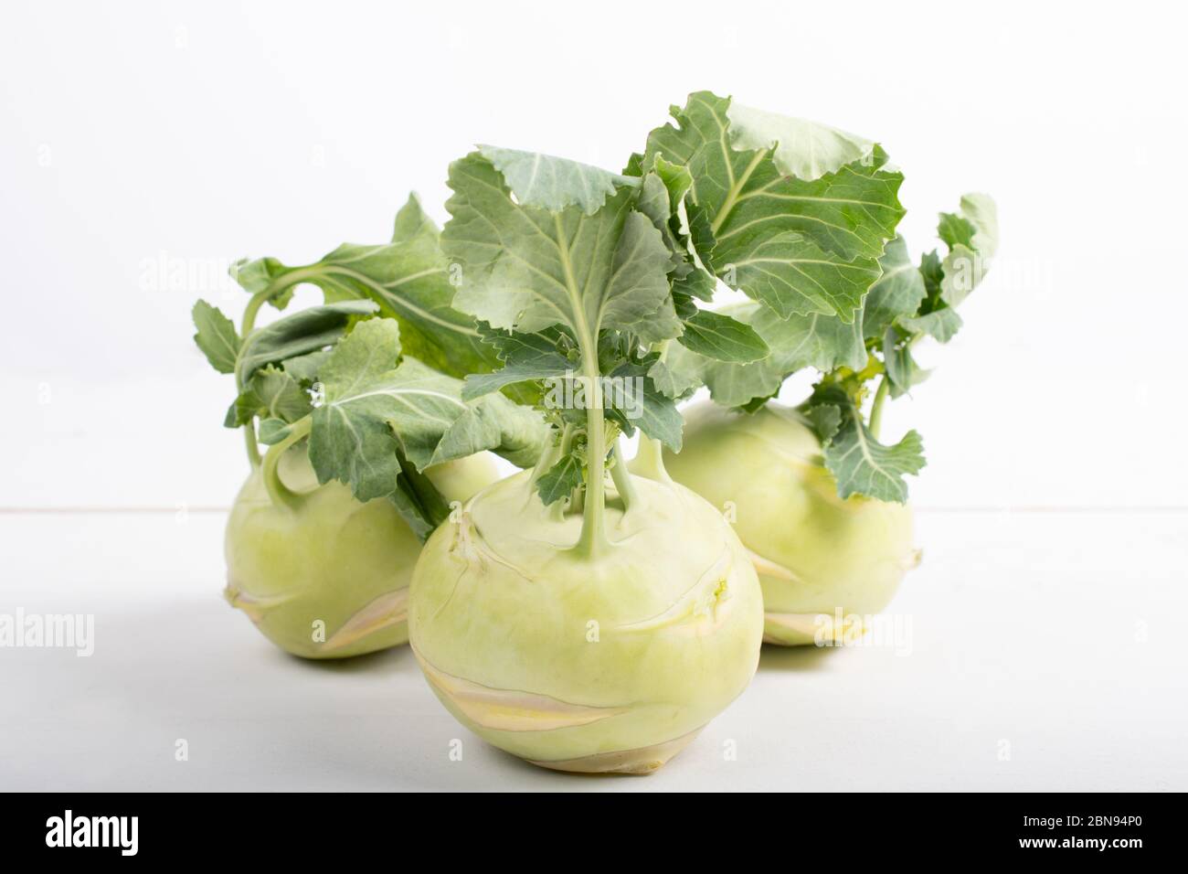 Three pieces of kohlrabi vegetable isolated on yellow simple background ...