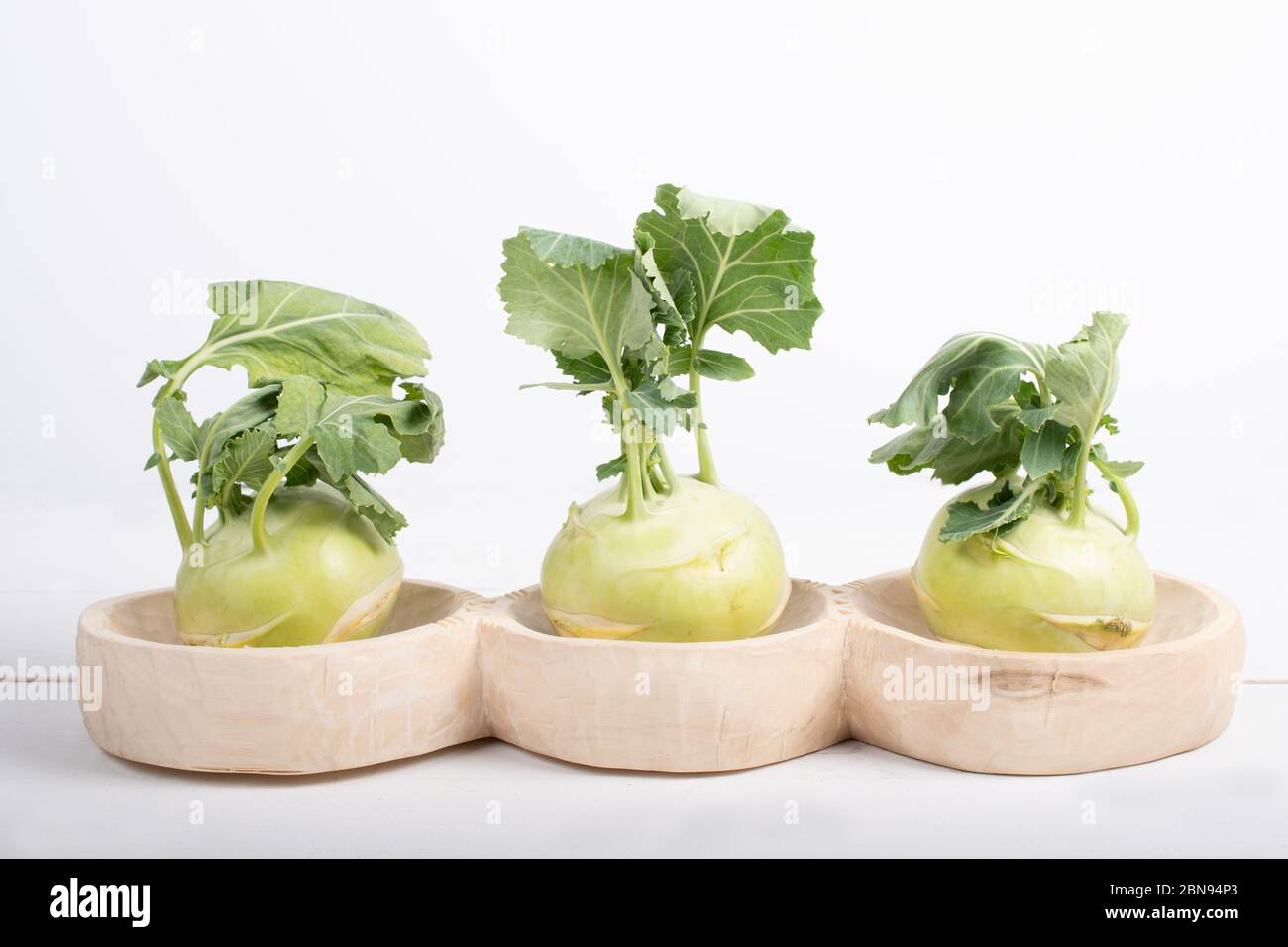 Three pieces of kohlrabi vegetable isolated on yellow simple background ...