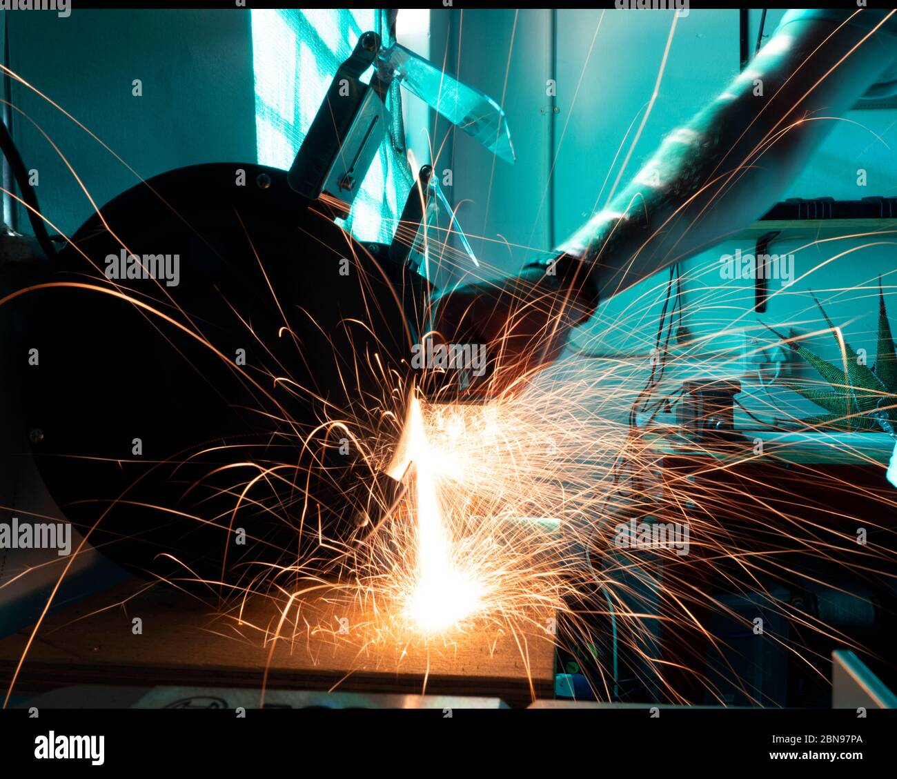 General factory worker grinds metal on a Bench Grinder Stock Photo - Alamy