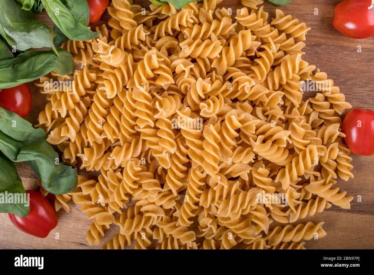 Gluten-free penne pasta from chickpeas, red lentils on wooden cutting ...
