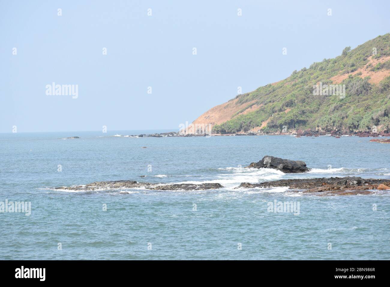 Black rocks in the seashore and mountain in the background..A view from ...