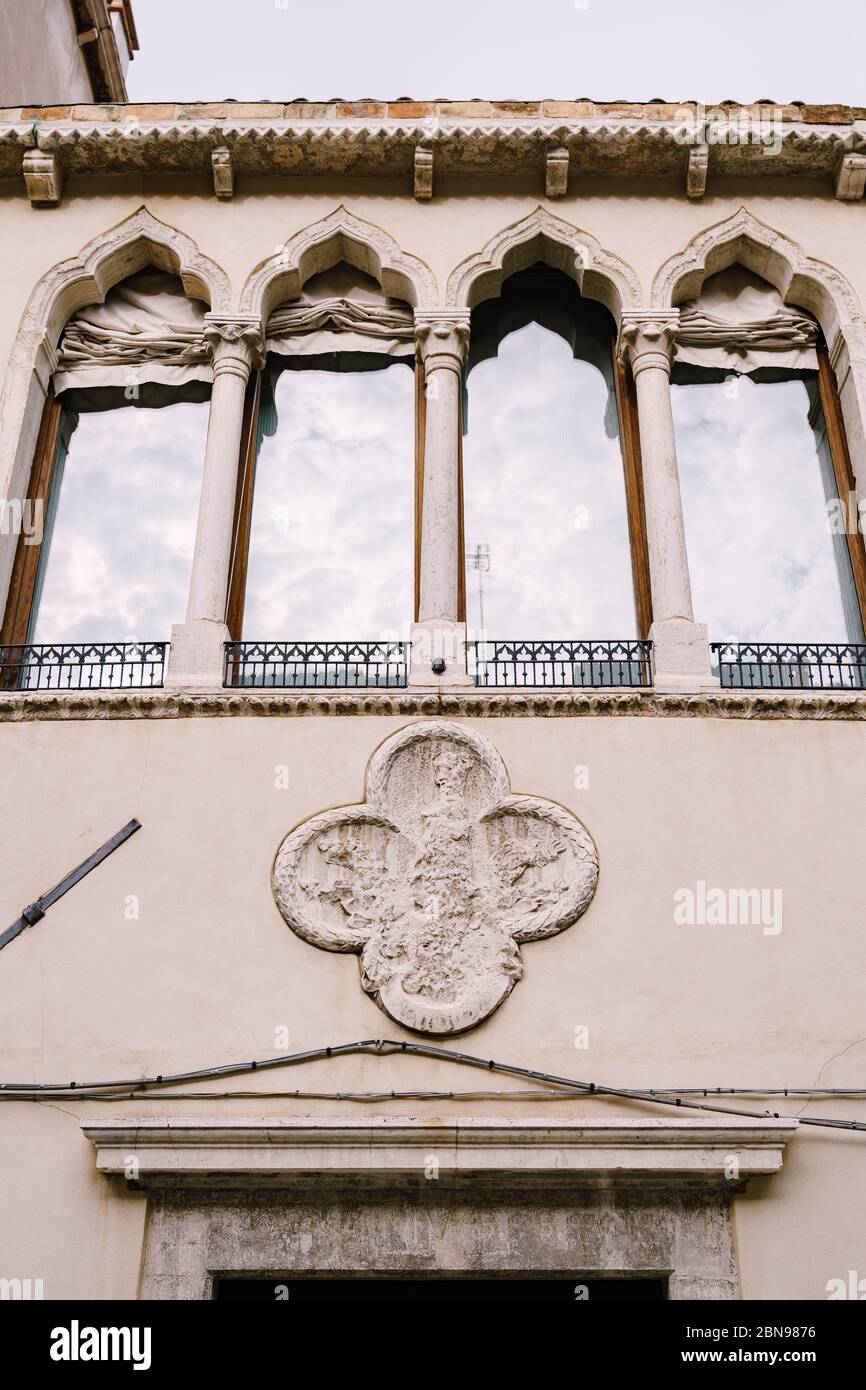 Close-ups of building facades in Venice, Italy. Four Venetian windows ...