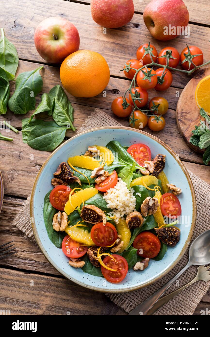 Colorful summer sweet salad with spinach, orange, cherry tomatoes ...