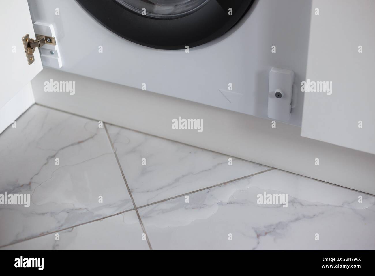 Spilled water leaked from washing machine built into the kitchen ...