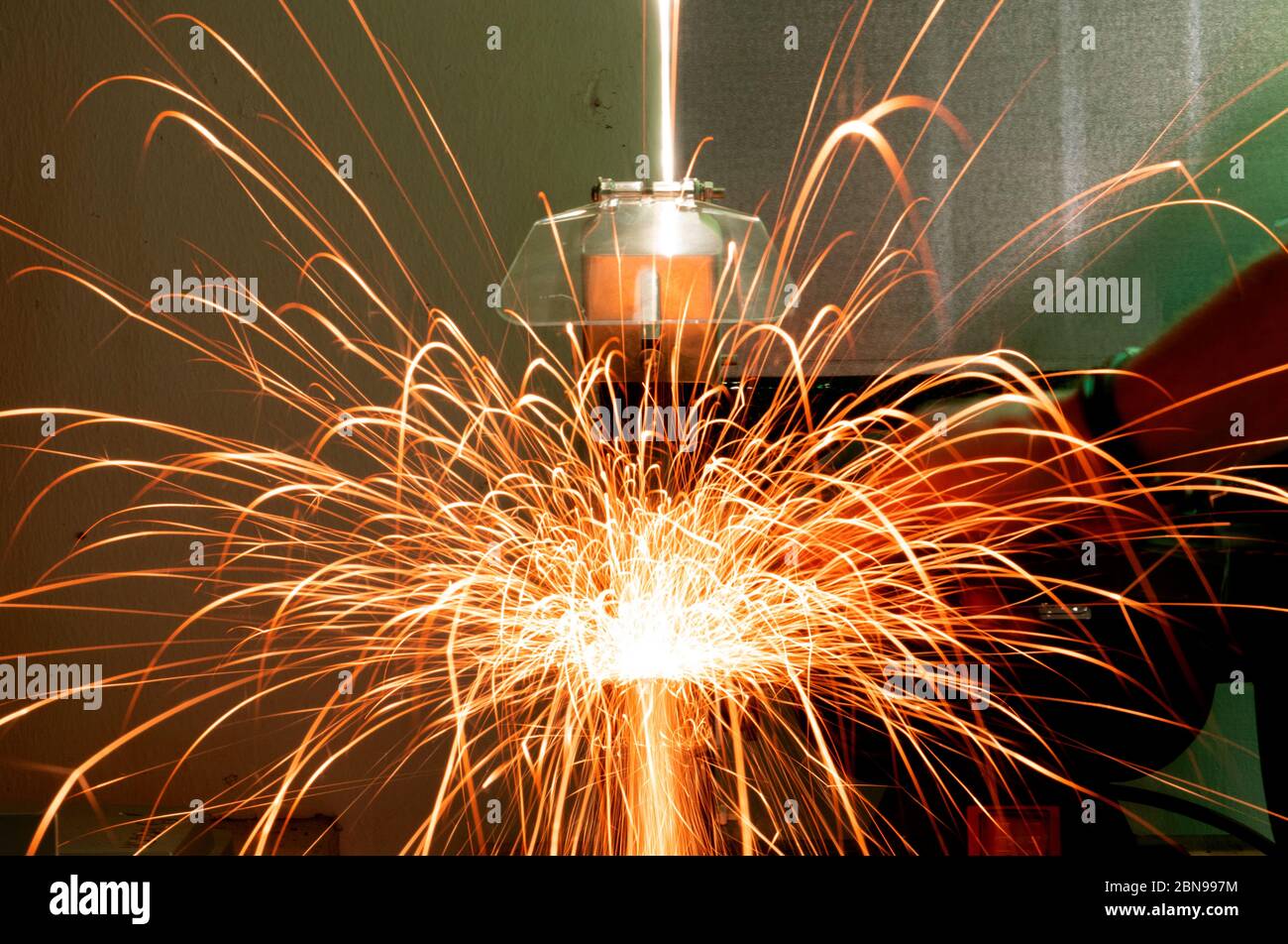 A bench grinder flares with grinding sparks Stock Photo - Alamy