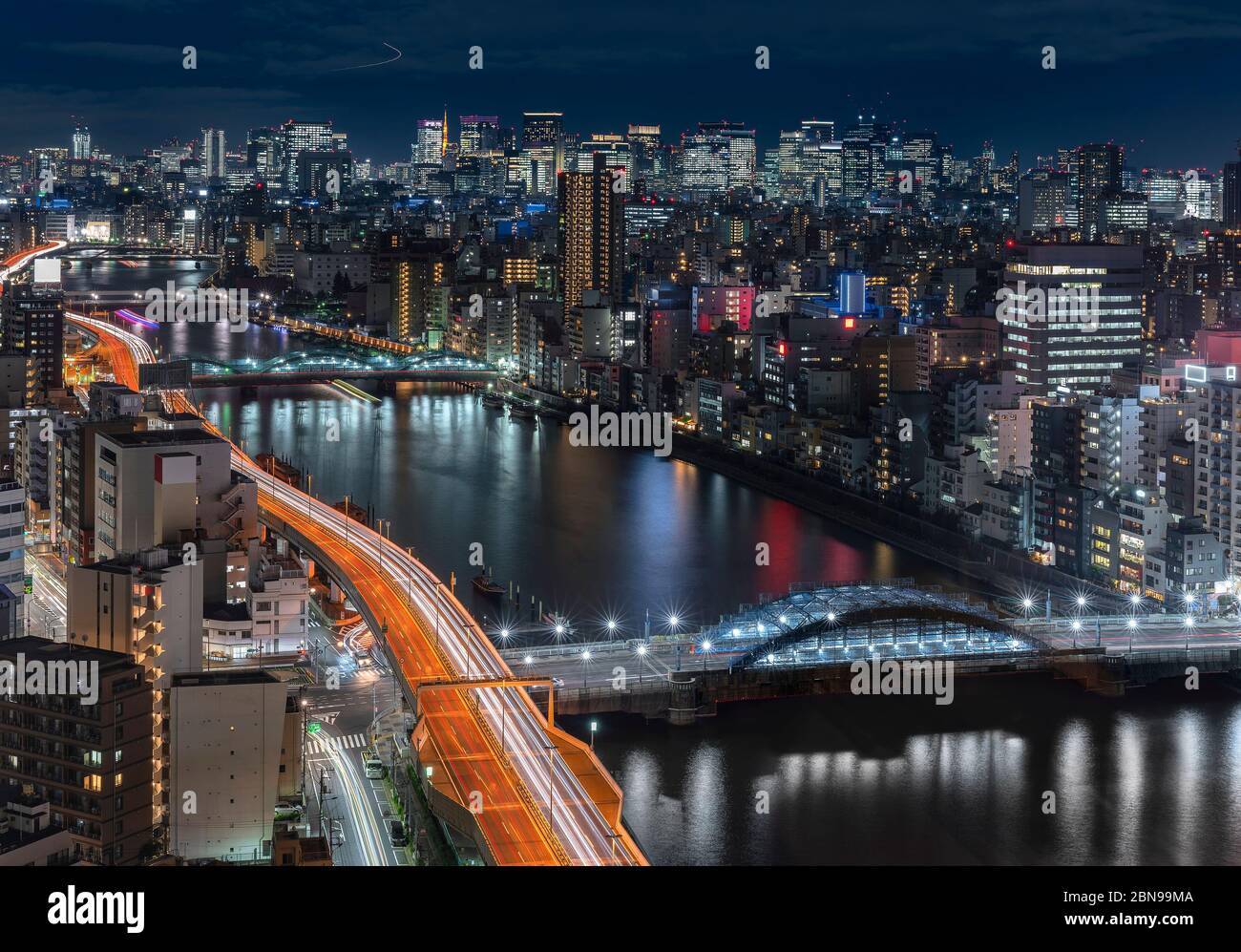 Aerial night panoramic view of the Sumida river bridges and higways ...