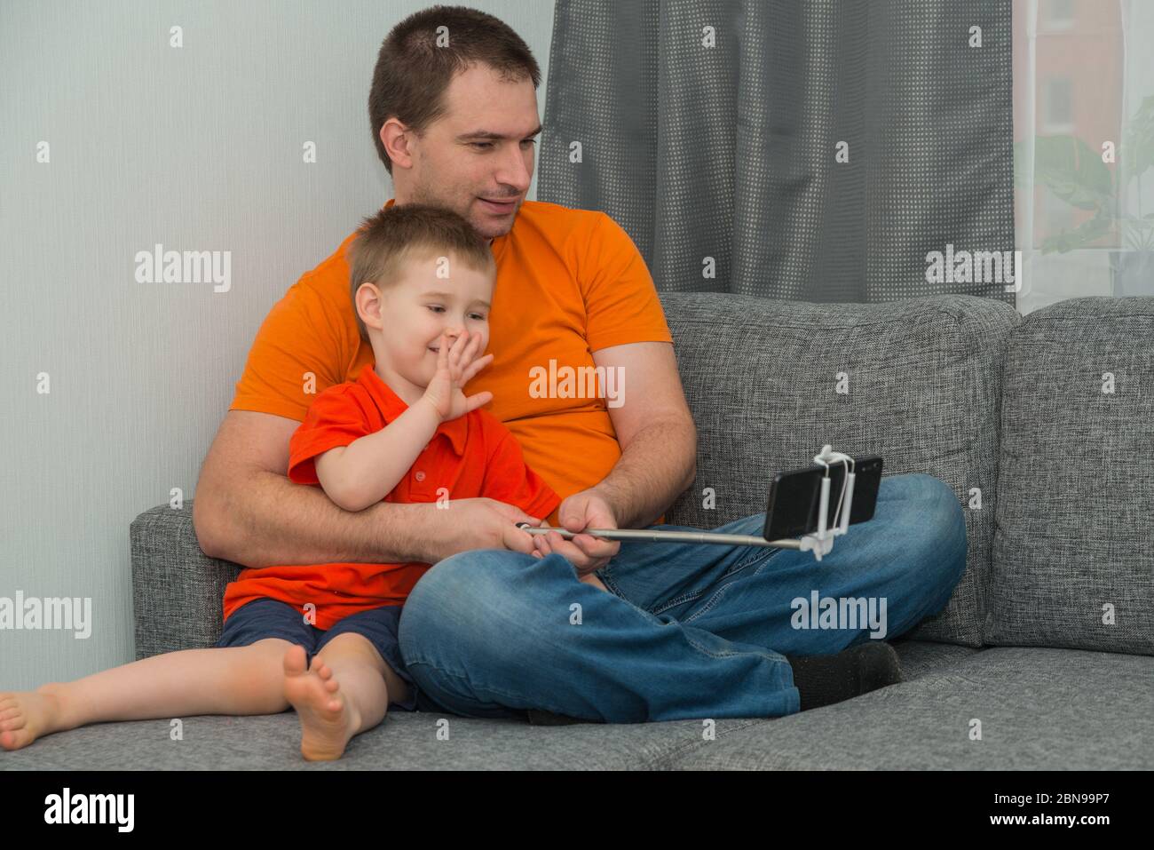 Boy and man looking in the smartphone during online call and smiling ...