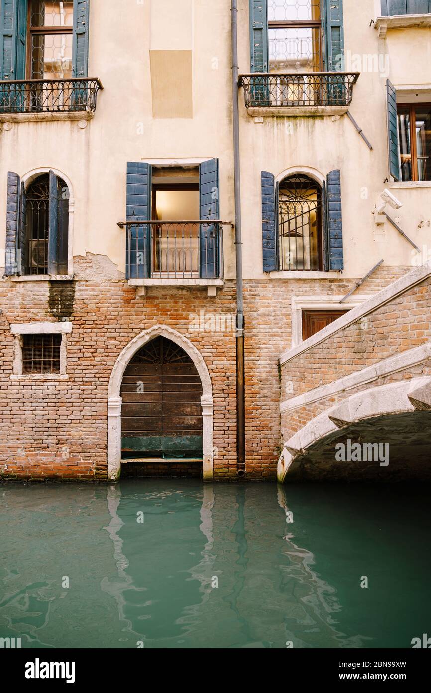 A brick building in the water in Italy, Venice. A brick bridge over a ...