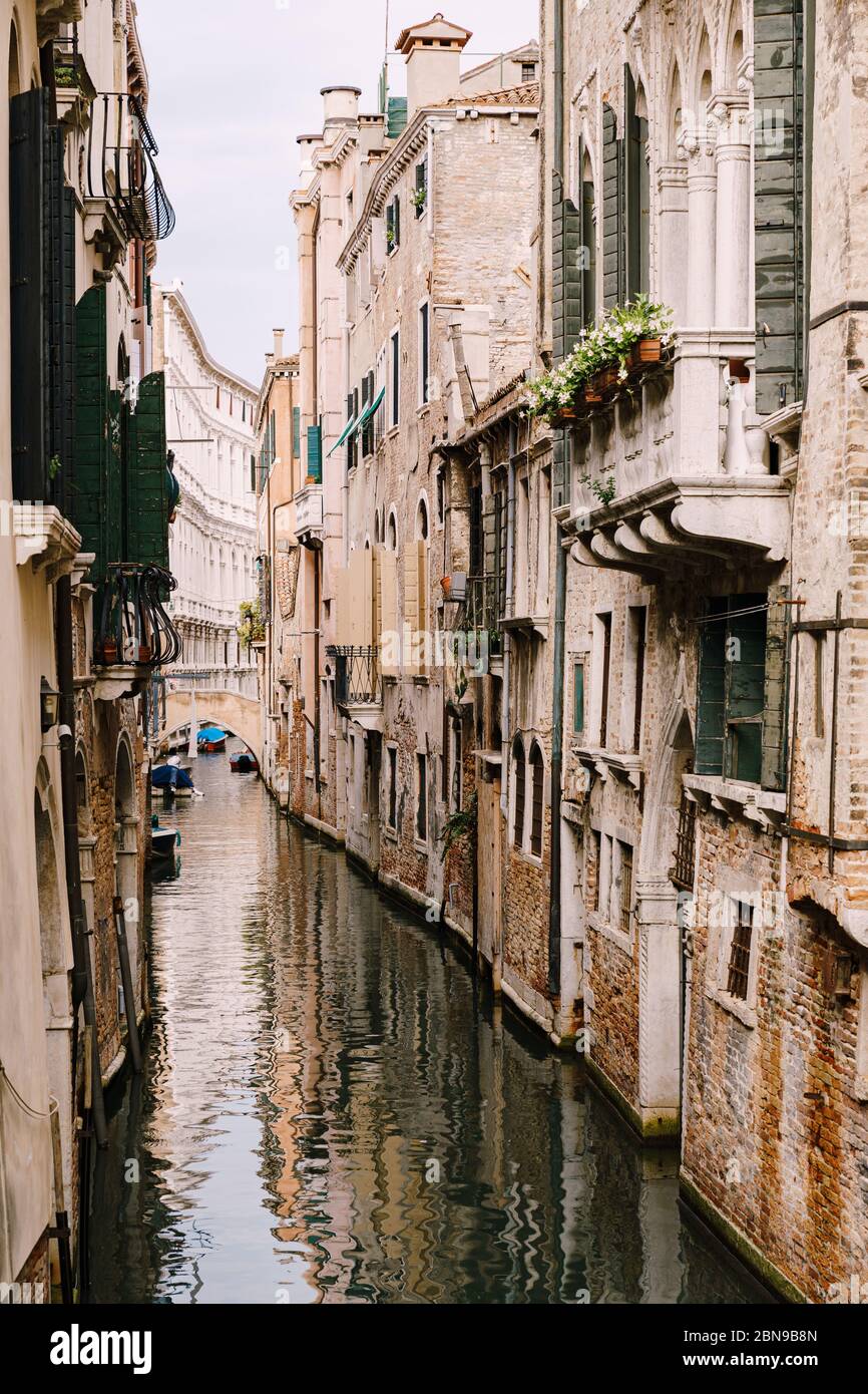 A narrow canal in Venice. Small canals between houses, a few meters ...