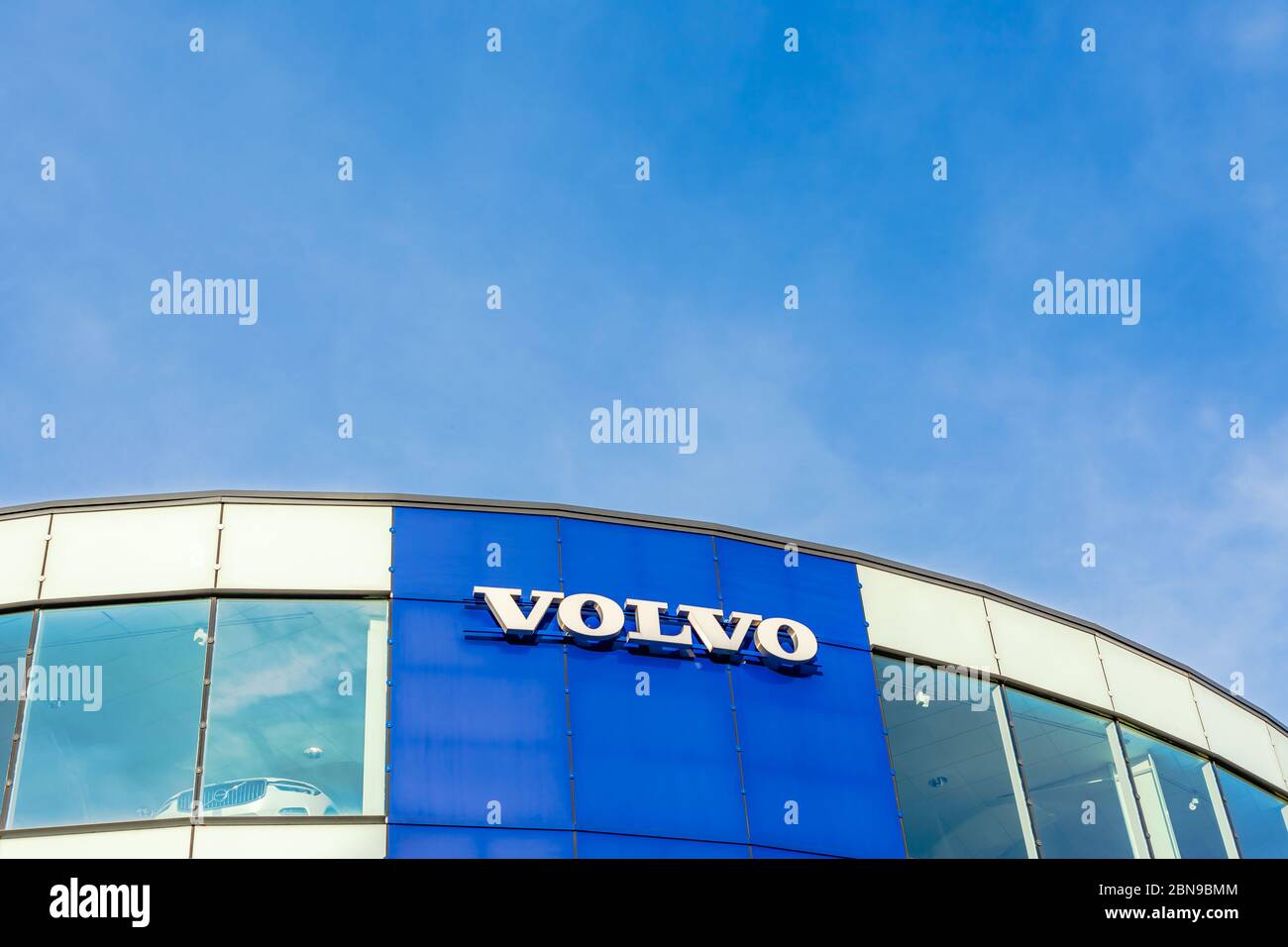 Volvo brand logo on bright blue sky background located on its sale ...