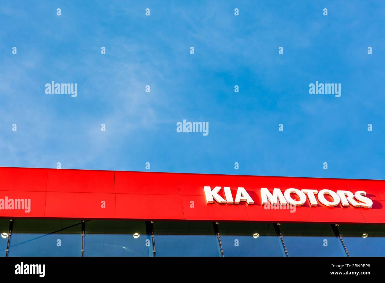 Kia motors corporation brand logo on bright blue sky background located on its dealer office ...