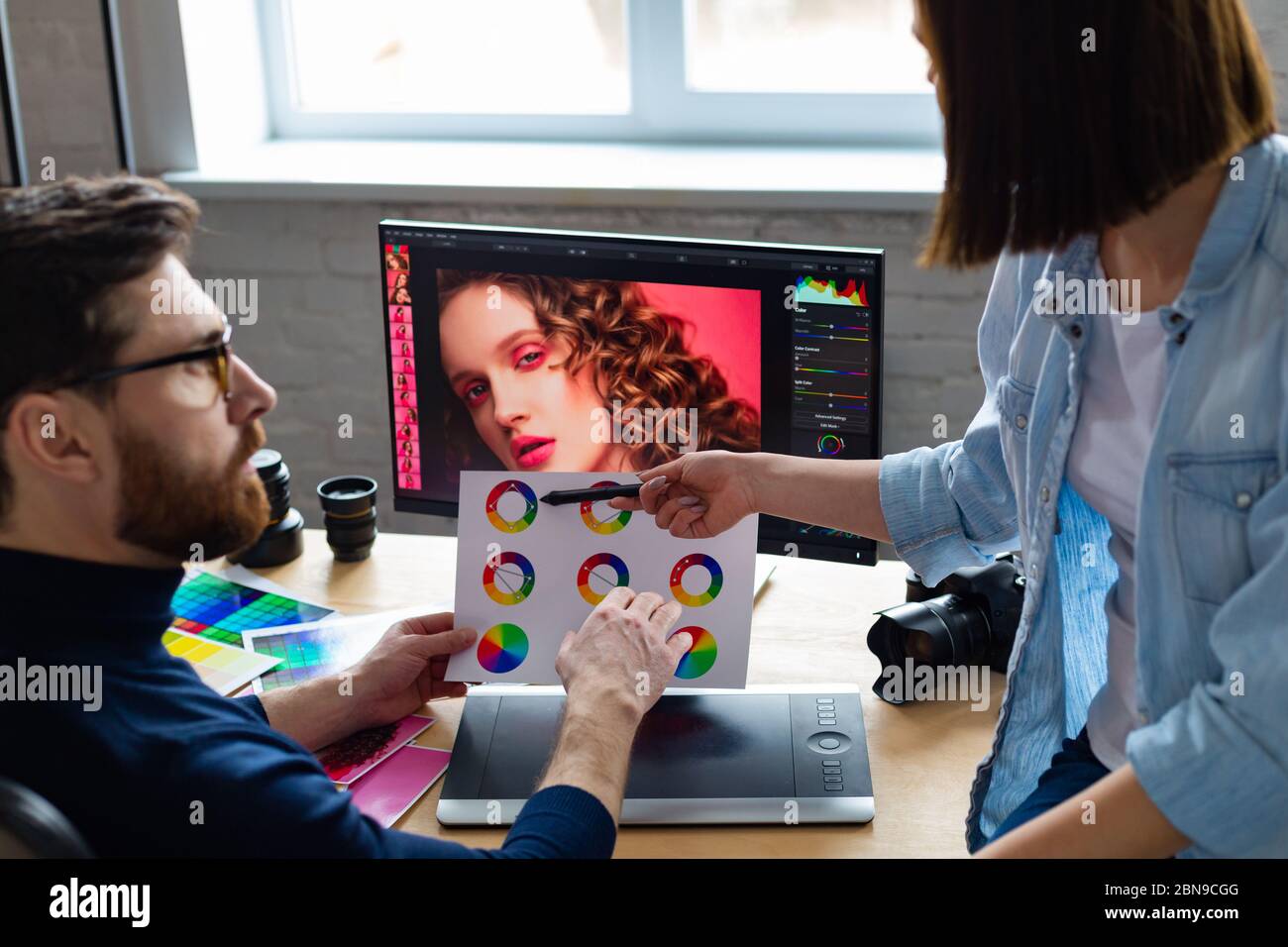 Partners discussing at work. Professional photographer and retoucher ...