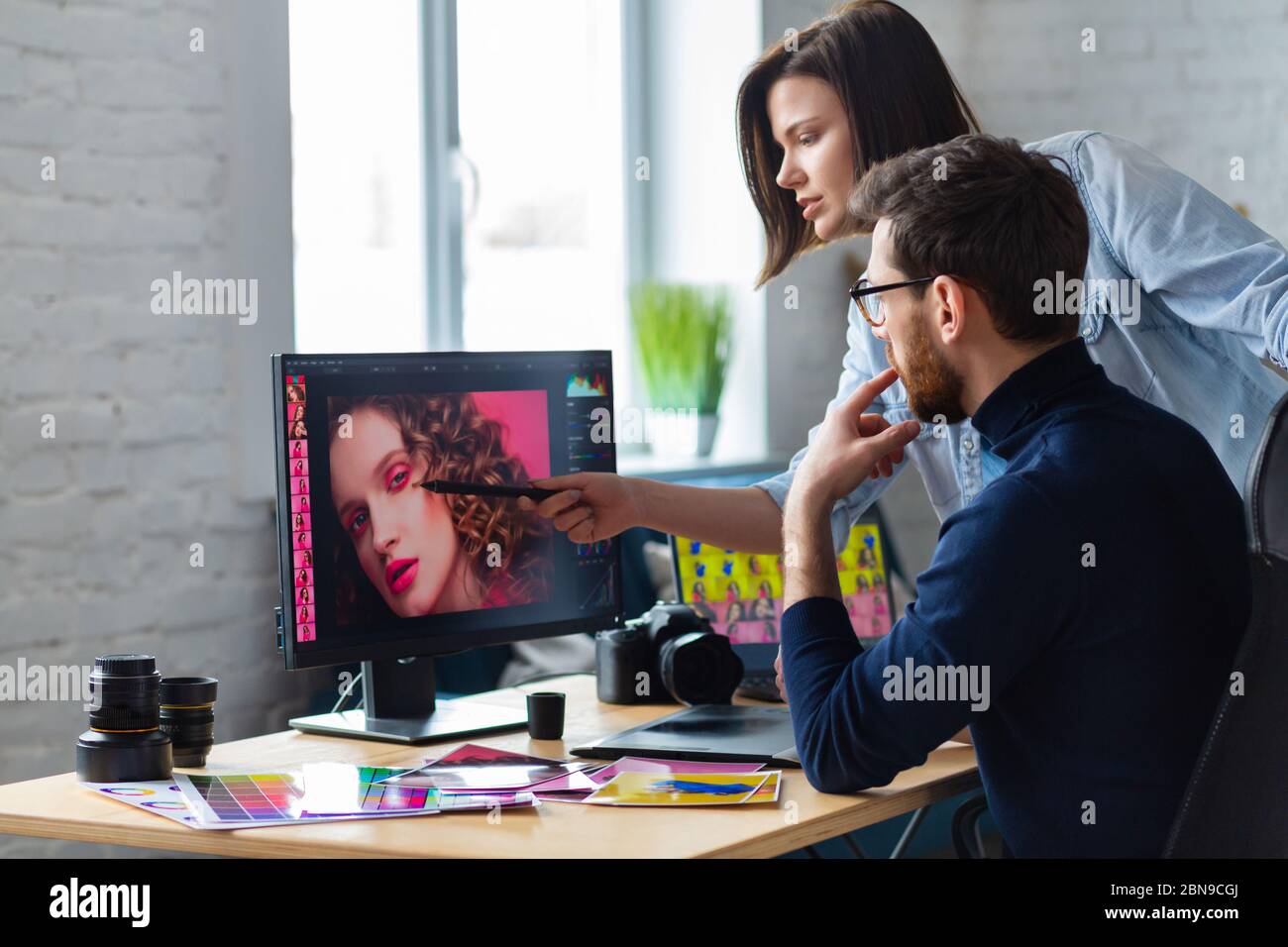 Partners discussing at work. Professional photographer and retoucher ...